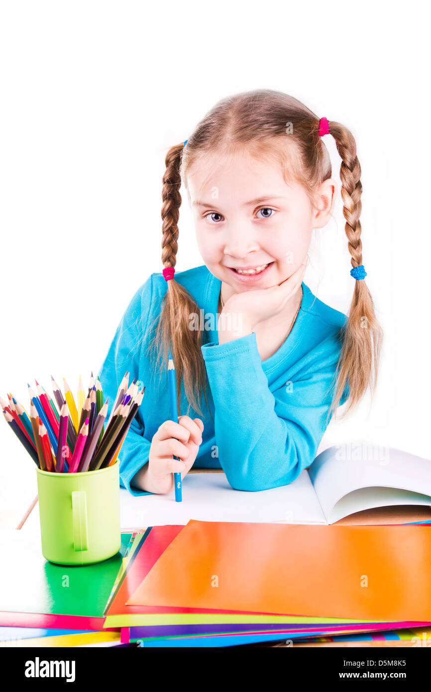 Adorable little smiling girl drawing a picture in a sketchbook with ...