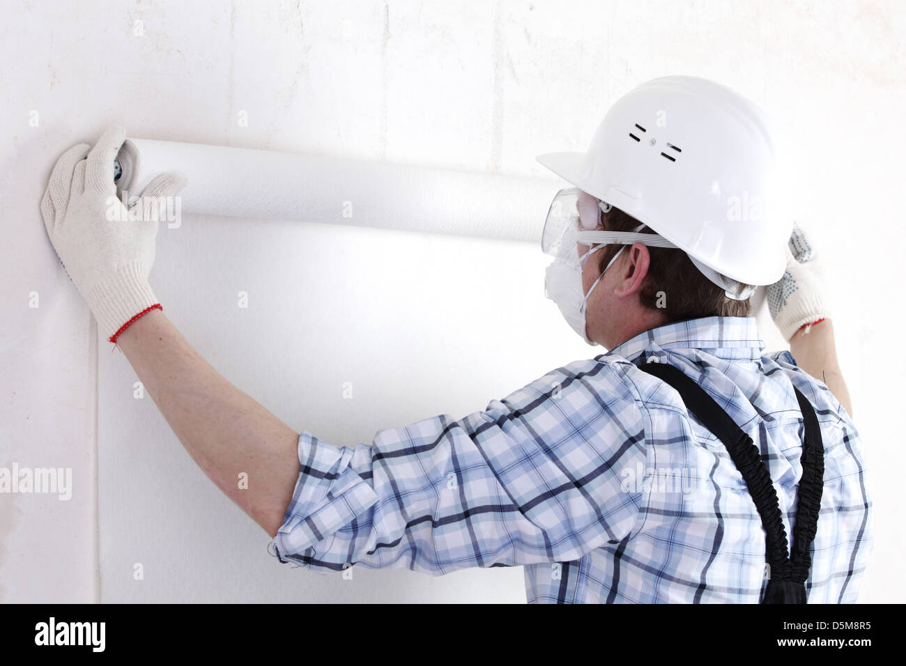 worker attaching wallpaper to wall Stock Photo - Alamy