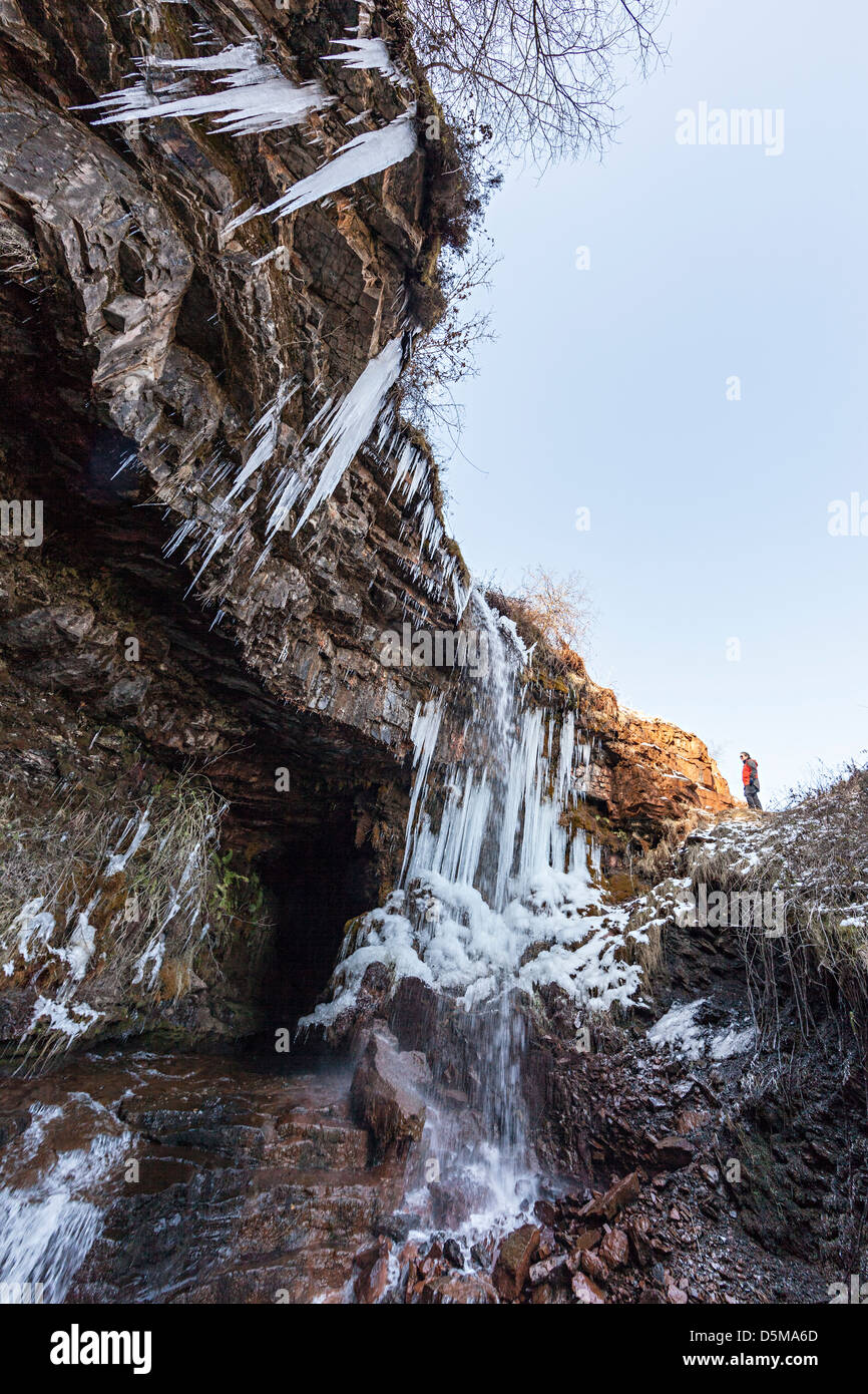 Person standing with icicles in the Clydach Gorge Wales, UK Stock Photo ...