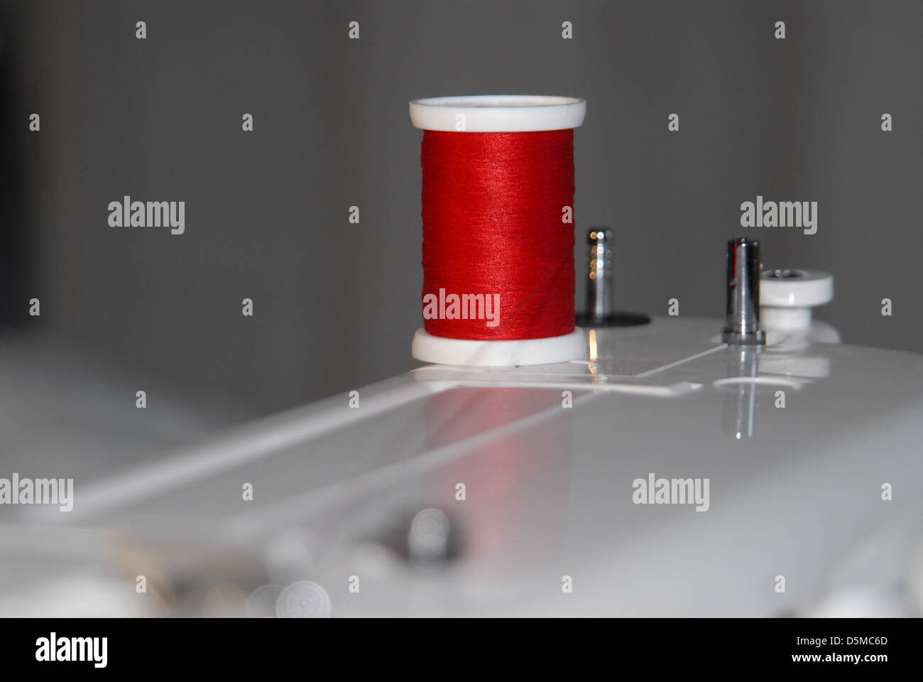 Red thread on spool pin Stock Photo - Alamy