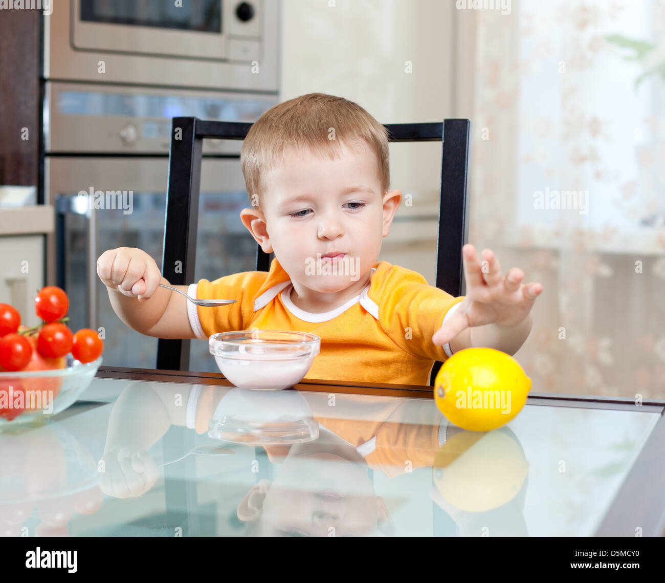 cute little boy eating healthy food at kitchen Stock Photo - Alamy
