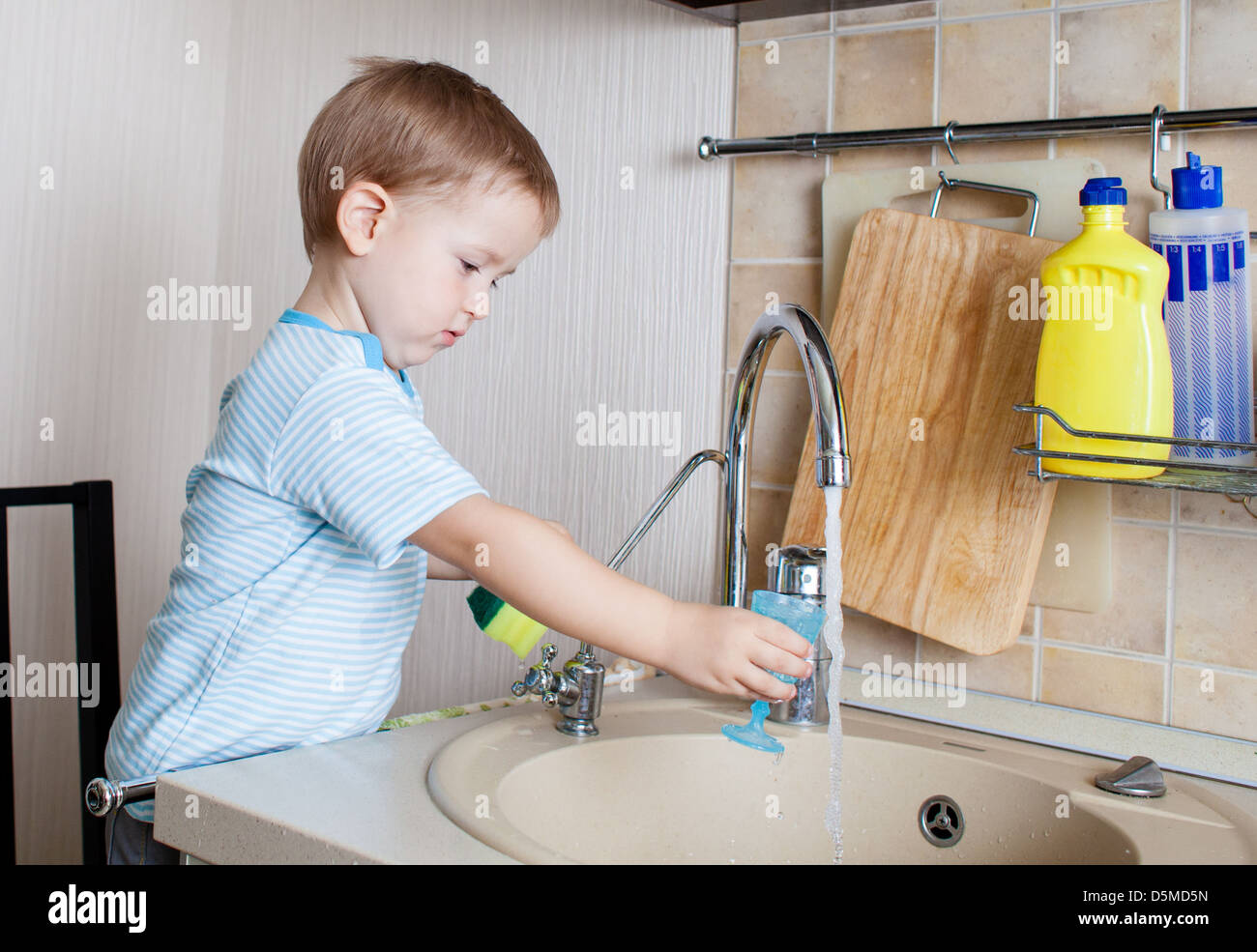 little child boy washing dish on kitchen Stock Photo - Alamy