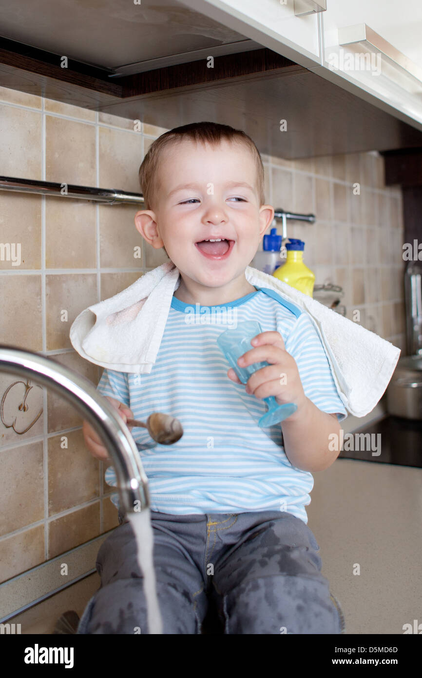 funny little child boy washing dish on kitchen Stock Photo - Alamy