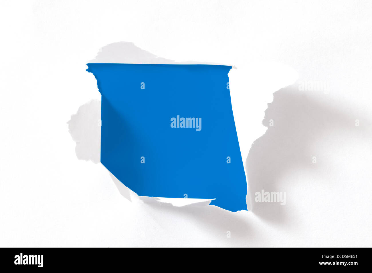 Breakthrough paper hole with blue background Stock Photo - Alamy