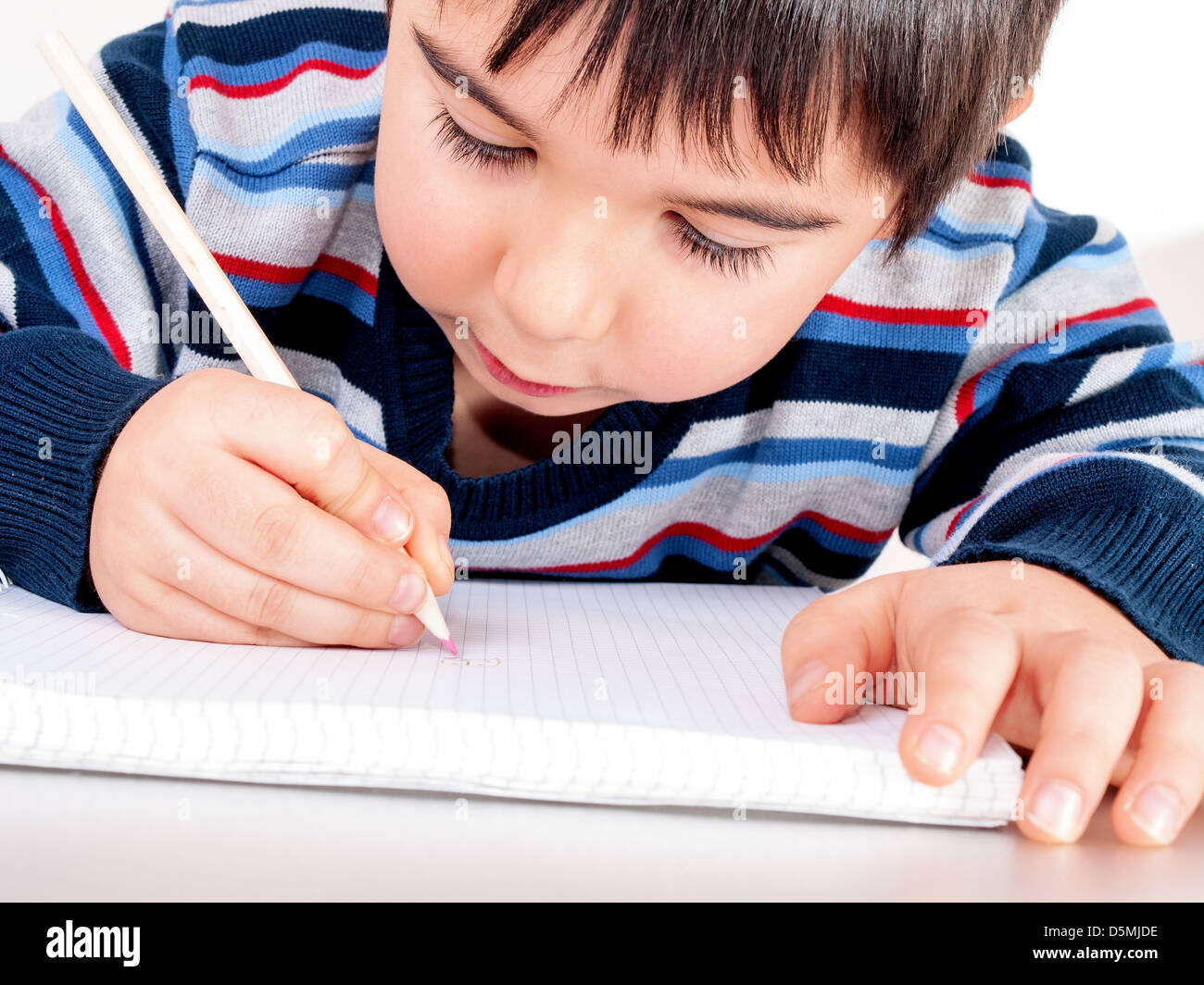 Boy draws a pencil drawing in the notebook Stock Photo - Alamy