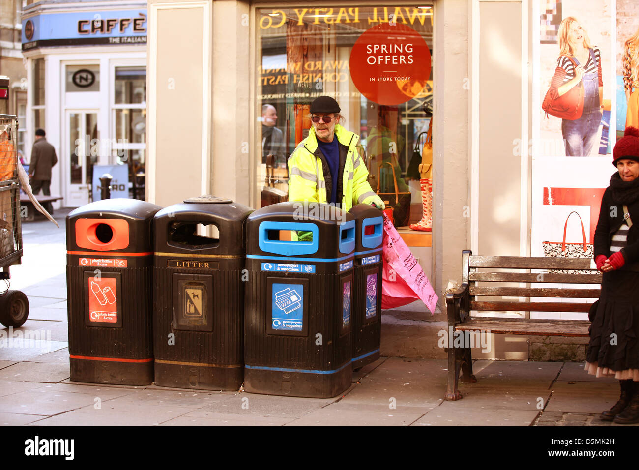 Council worker in a bright yellow coat emptying the recycling bins in ...