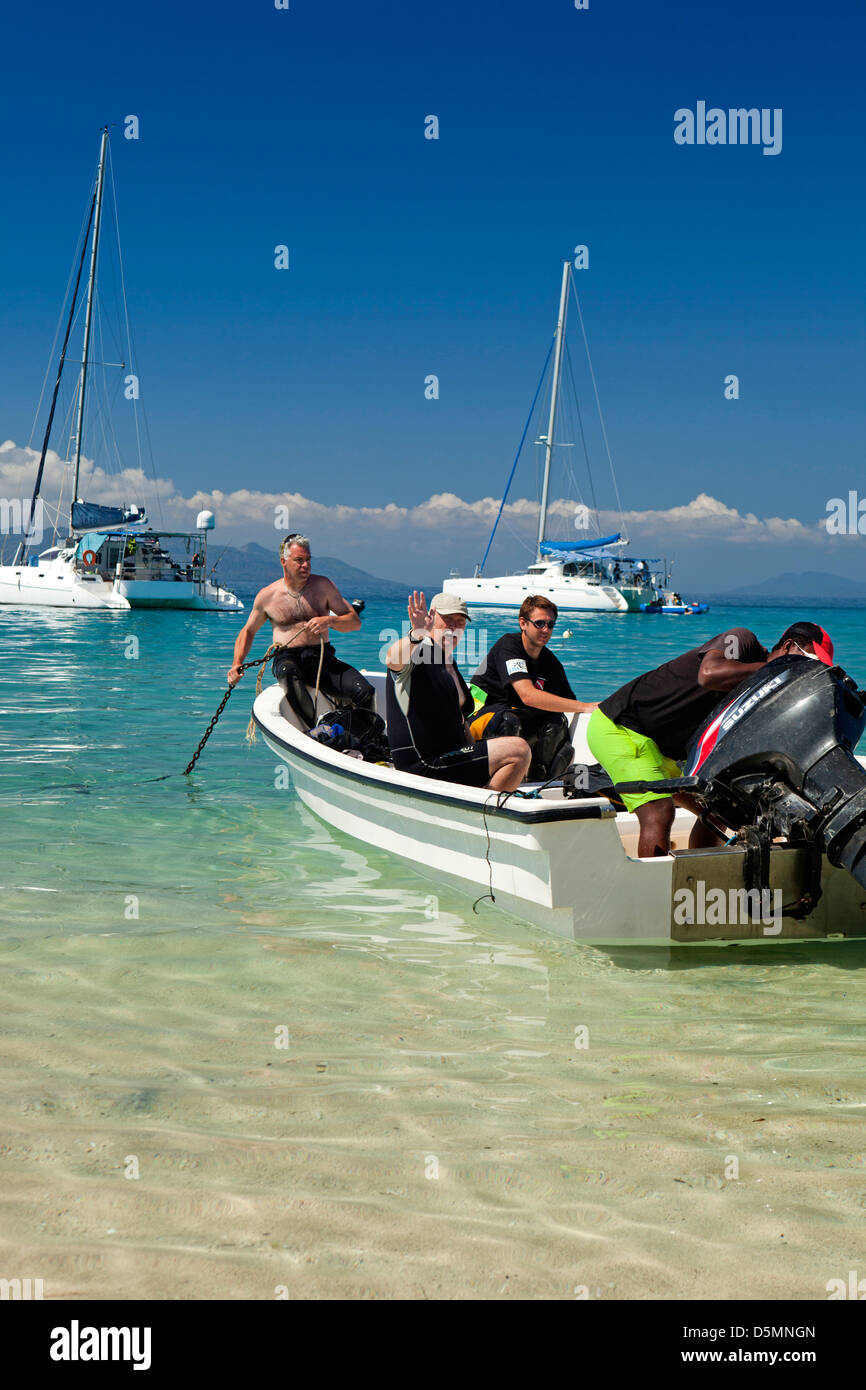 Madagascar, Nosy Be, Nosy Tanikely island scuba divers in boat leaving ...