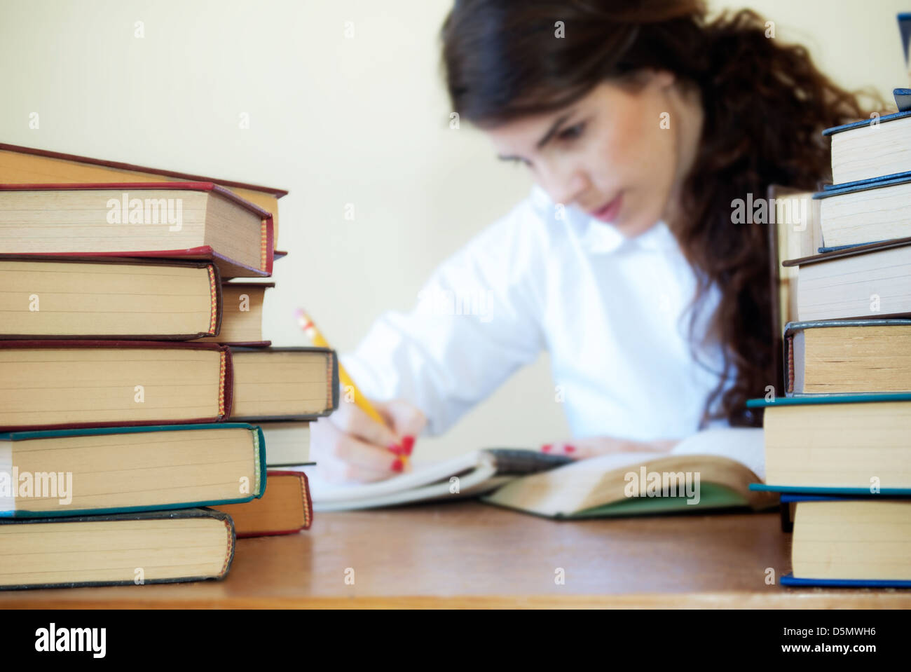 Young woman studying with a lot of books Stock Photo - Alamy