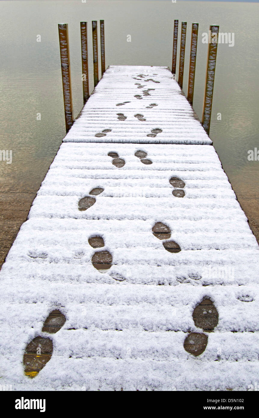 Dock on a lake with human footprints going out and back in snow Stock ...