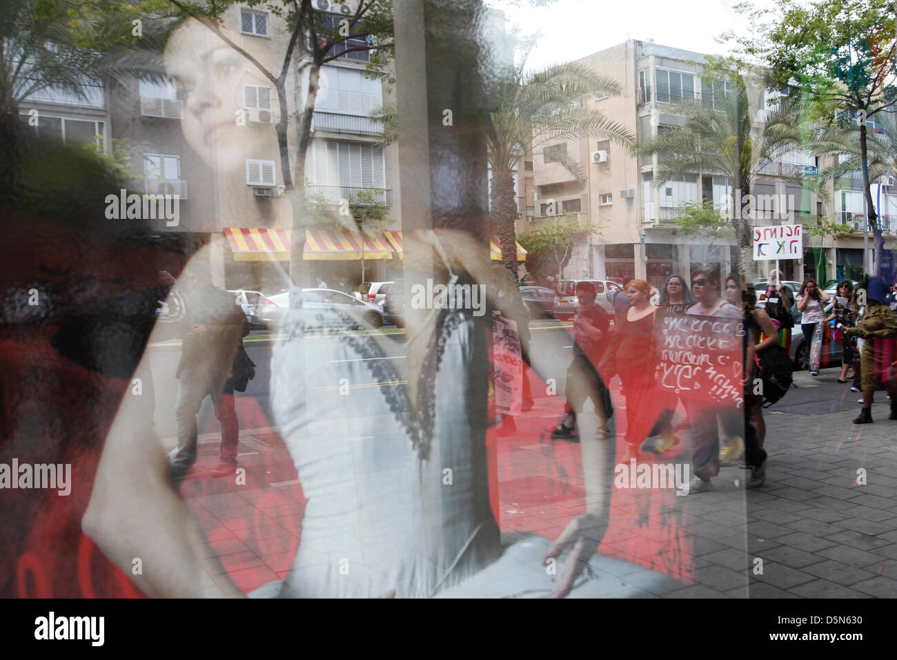 Women marching with placards are reflected in a shop window during the ...
