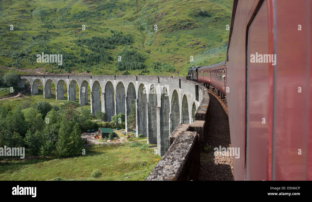 Steam locomotive hauls train of coaches over Glenfinnan viaduct Stock ...