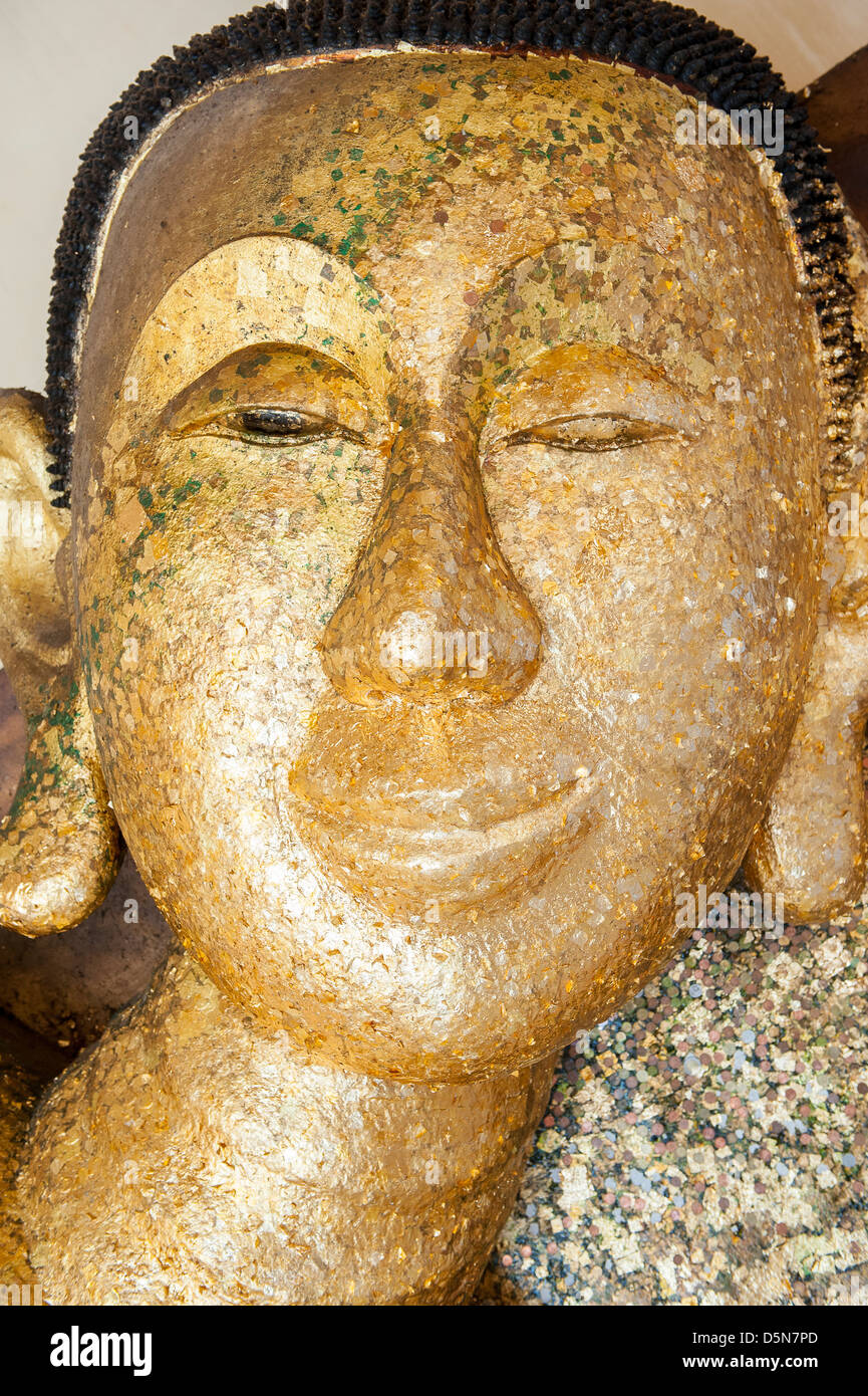 Close up of a Buddha face covered by worshippers in gold leaf Stock ...