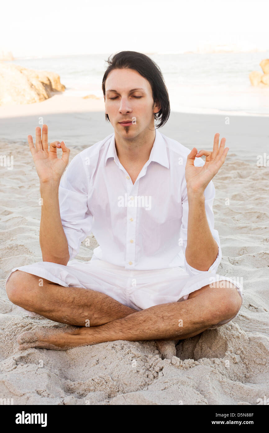 Man Meditating on Beach Stock Photo - Alamy