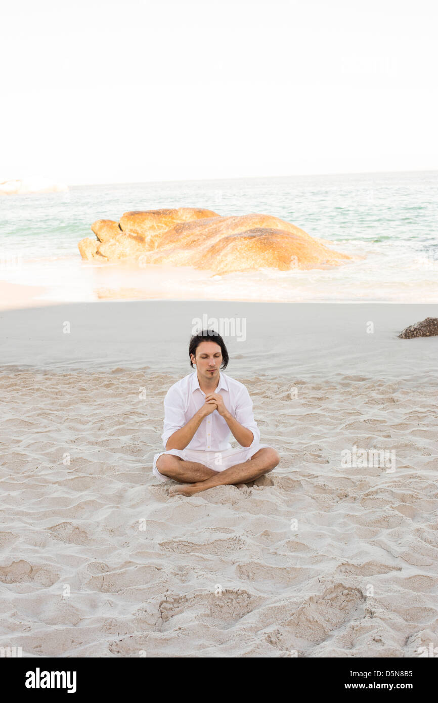 Man Meditating on Beach Stock Photo - Alamy