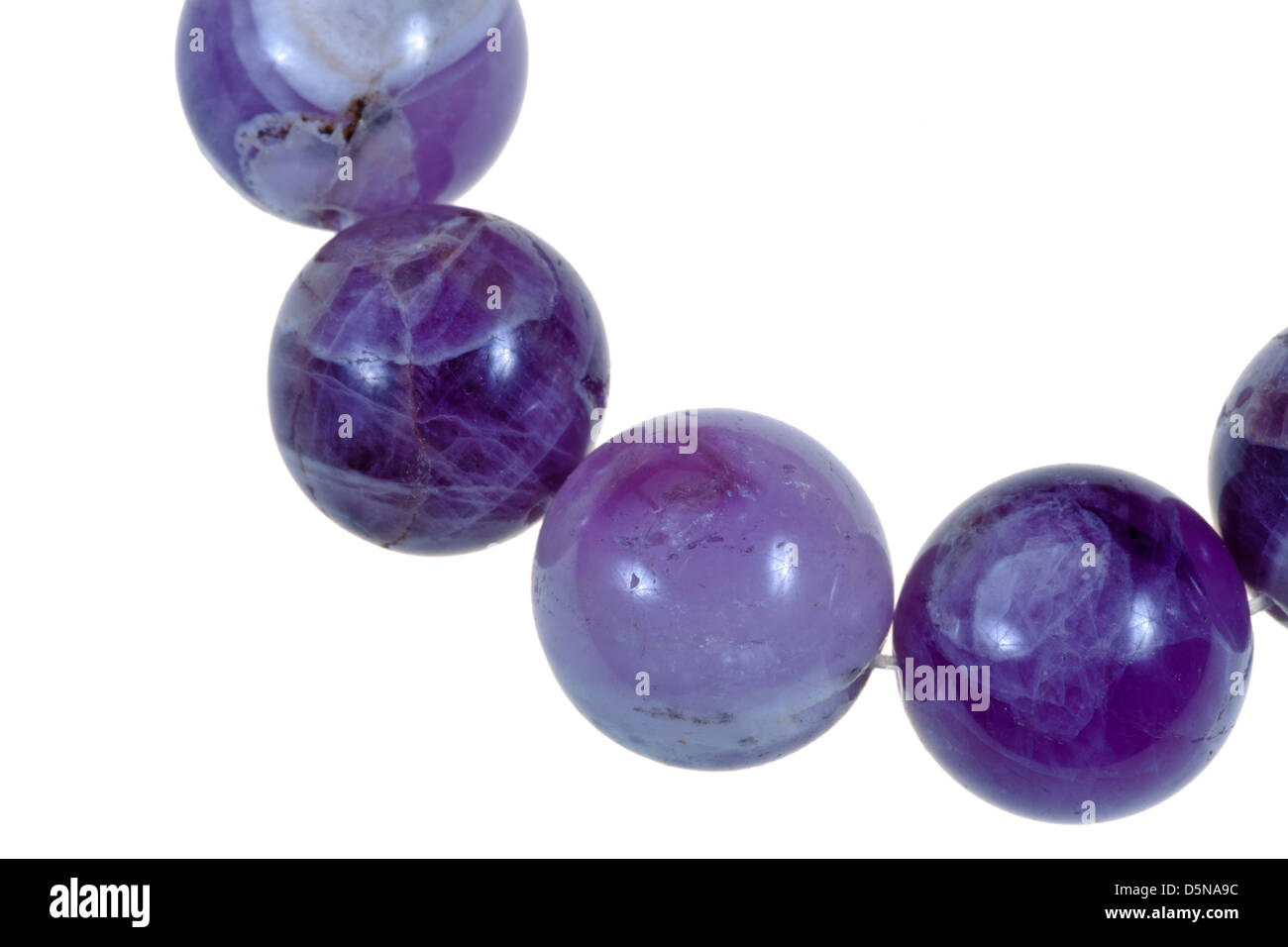 string of round amethyst beads close up isolated on white background ...