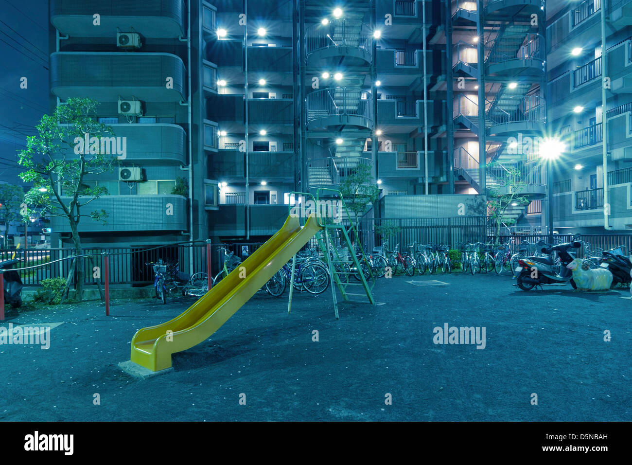 blue tinted city playground by night near big residential building ...