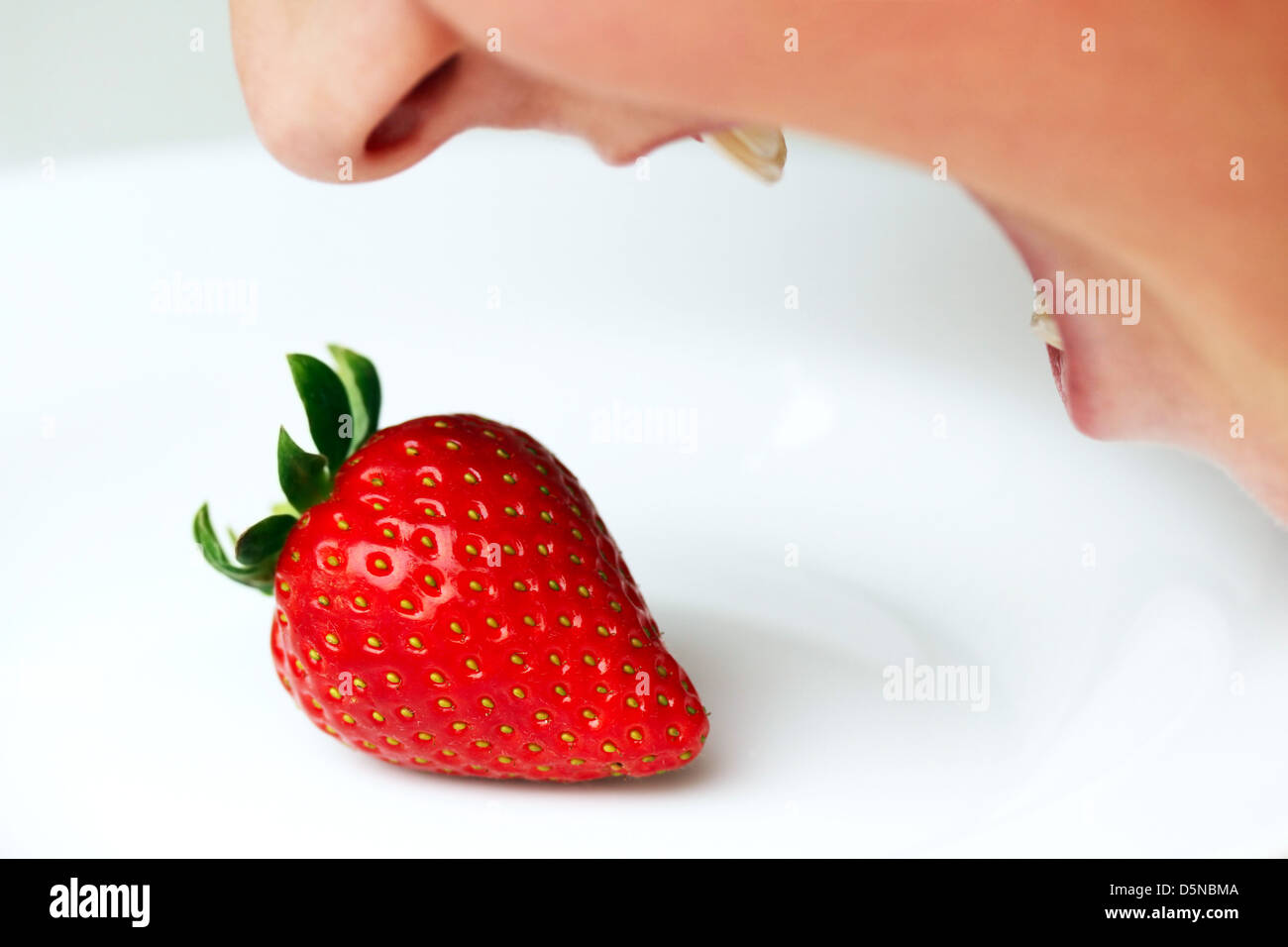 Young man eating a healthy strawberry Stock Photo - Alamy