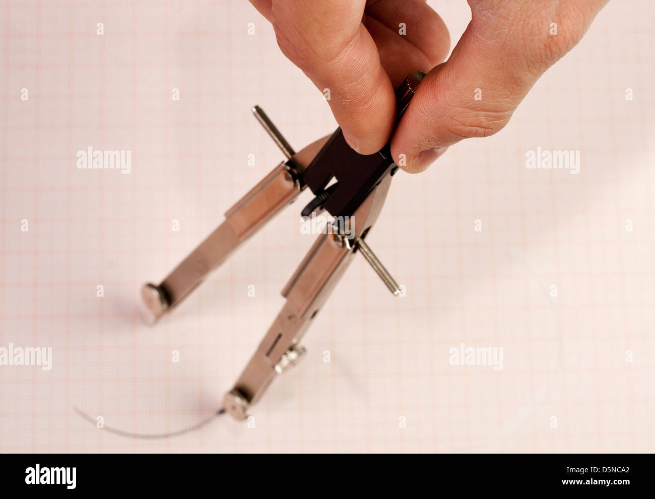 Hand drawing a circle with drawing compass on graph paper Stock Photo ...