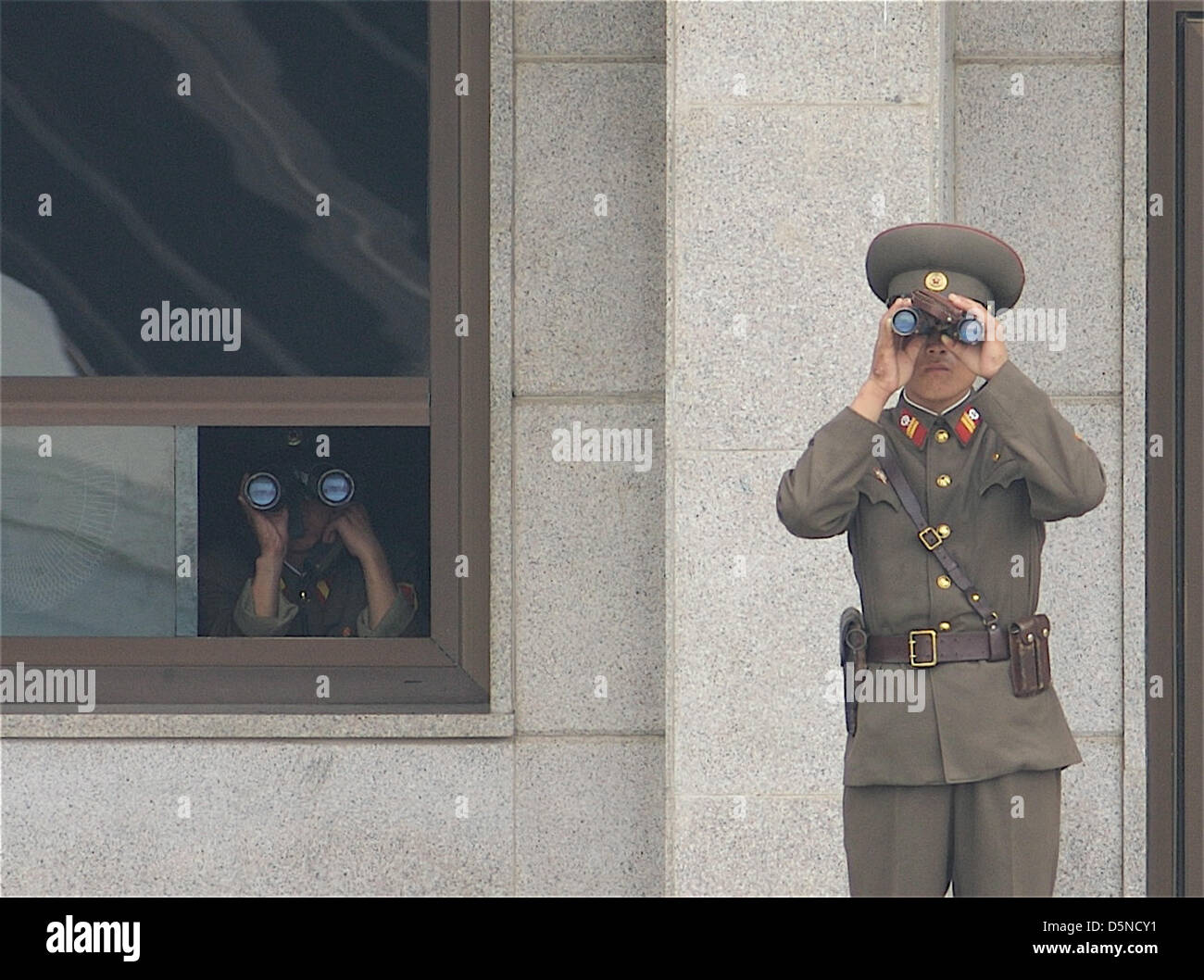 A North Korean guard stands looking south along the Demilitarized Zone ...