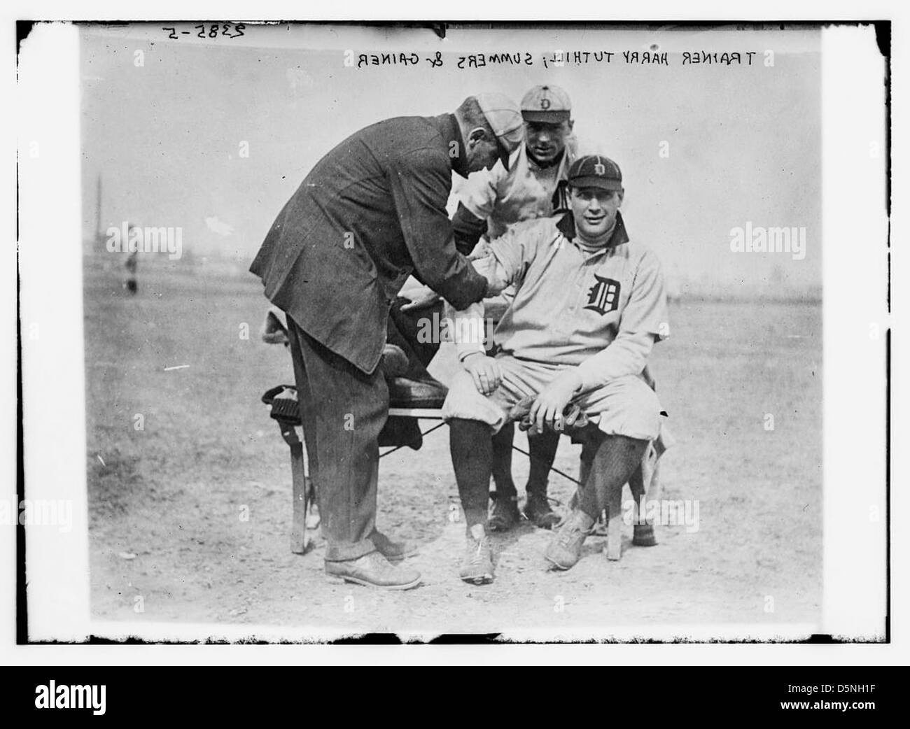 This photograph shows baseball trainer Harry Tuthill treating Ed ...