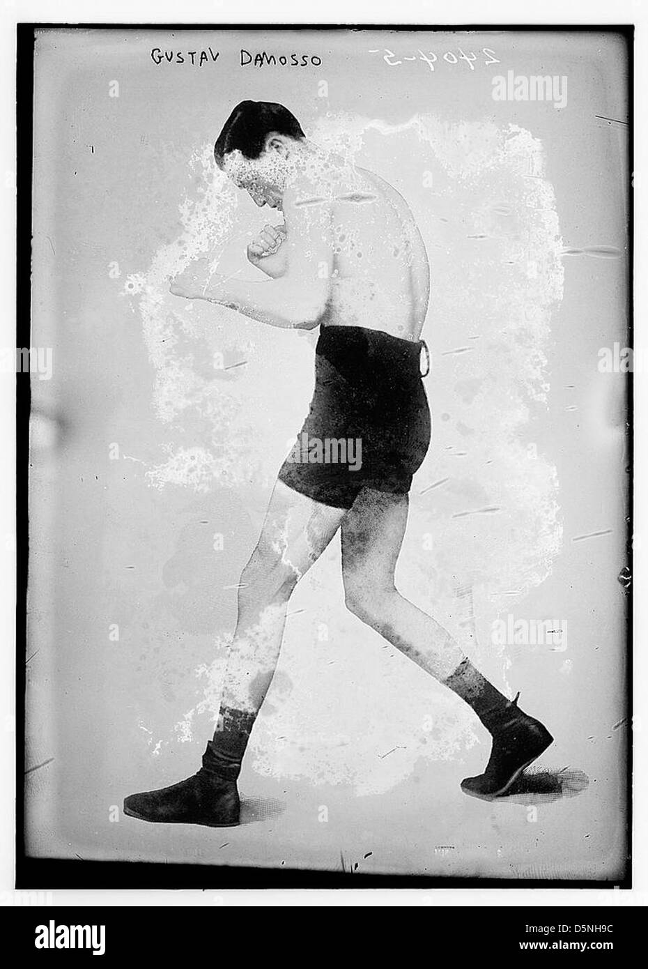 A portrait of Gustav Damosso, a boxer, captured in a black-and-white ...