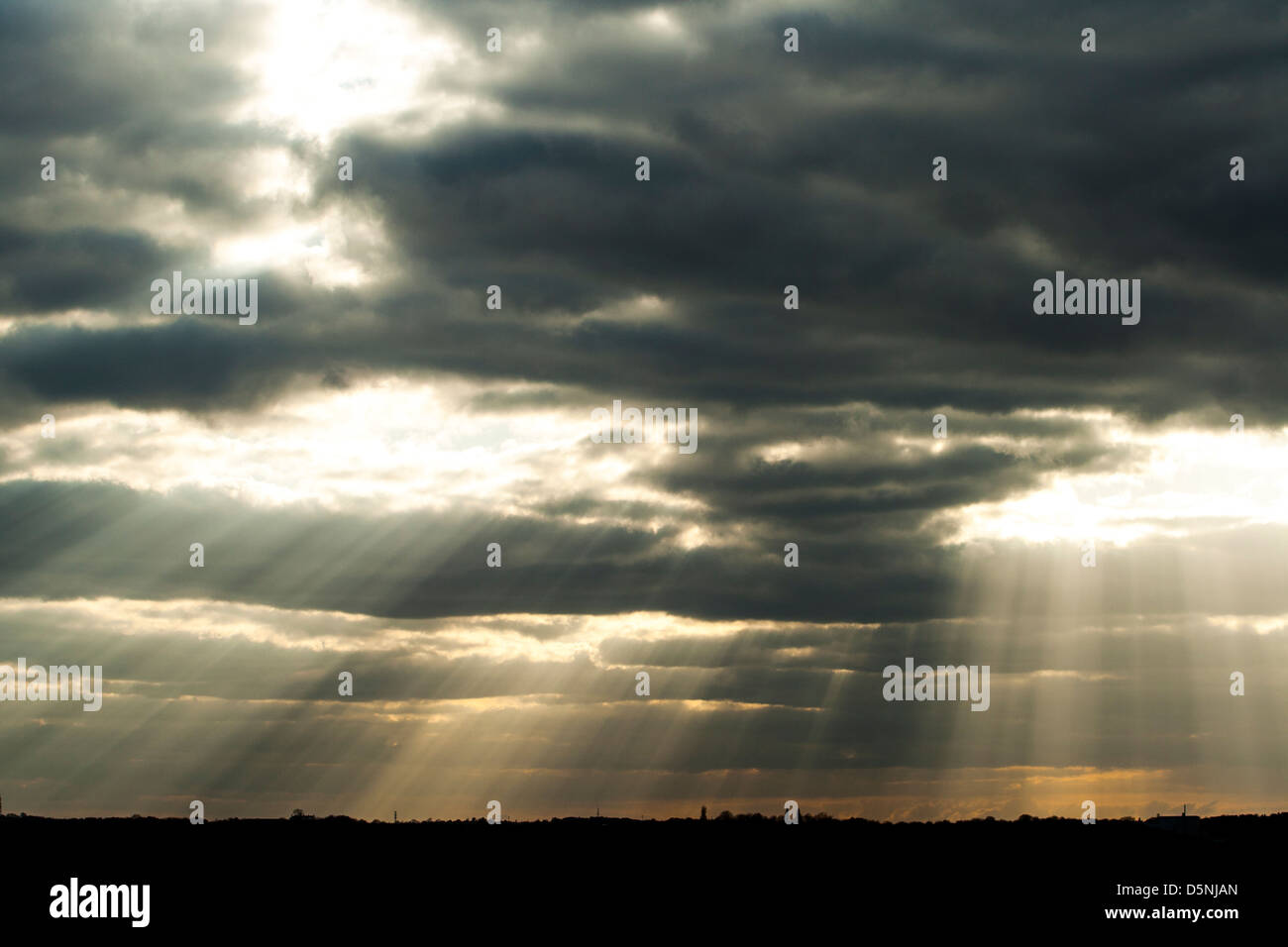 sunshine shining through the dark clouds Stock Photo - Alamy