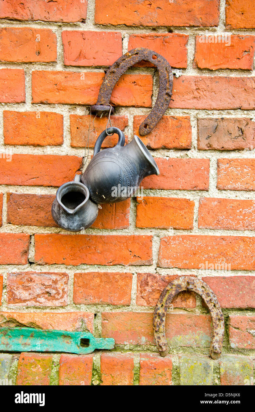 old red bricks wall with rusted horseshoe and black jug Stock Photo - Alamy