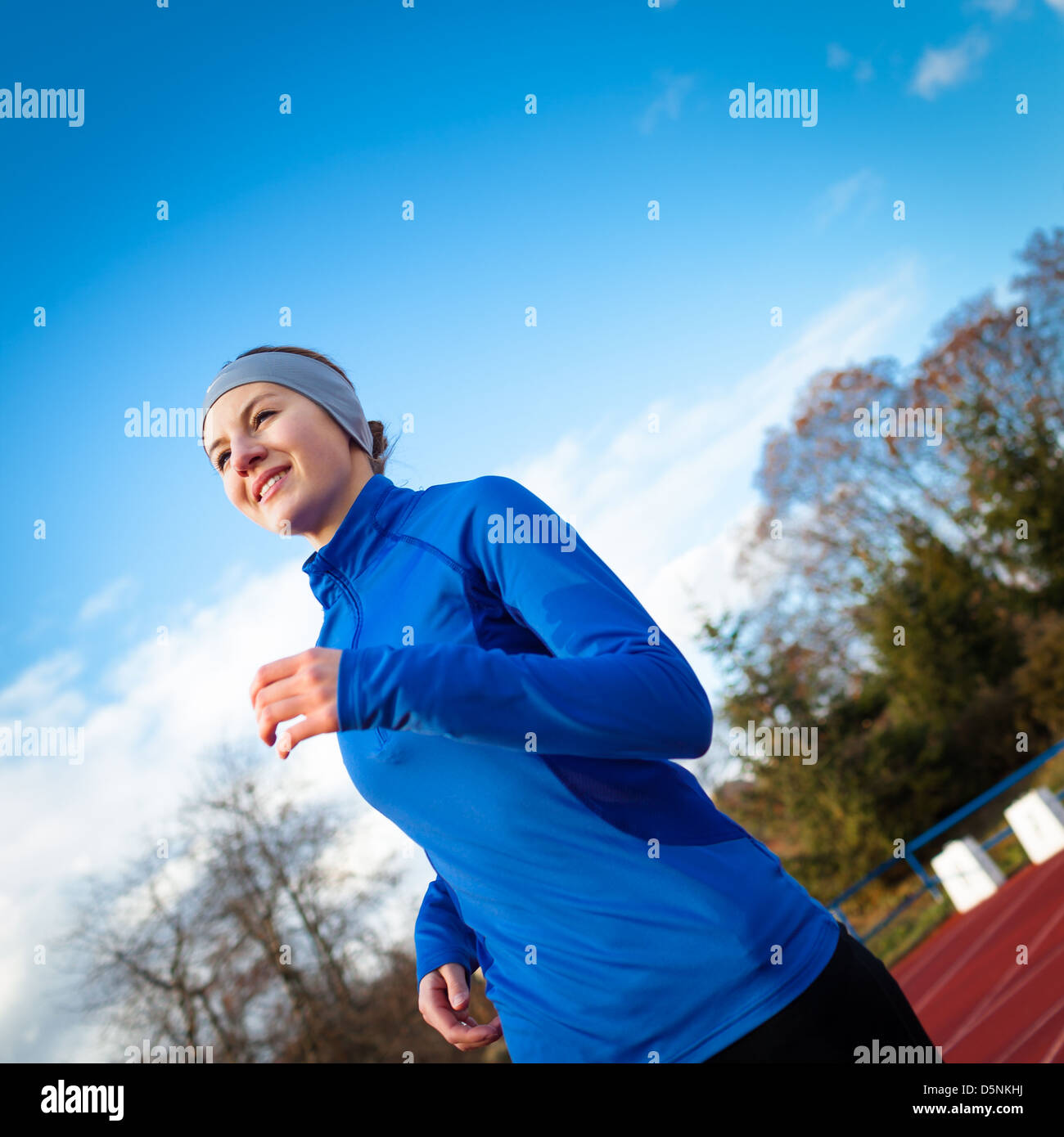 Young woman running at a track and field stadium Stock Photo - Alamy