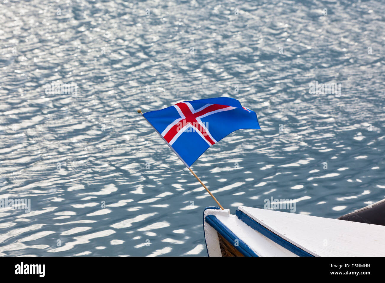 The flag of Iceland waving in the wind on a background of blue sea ...