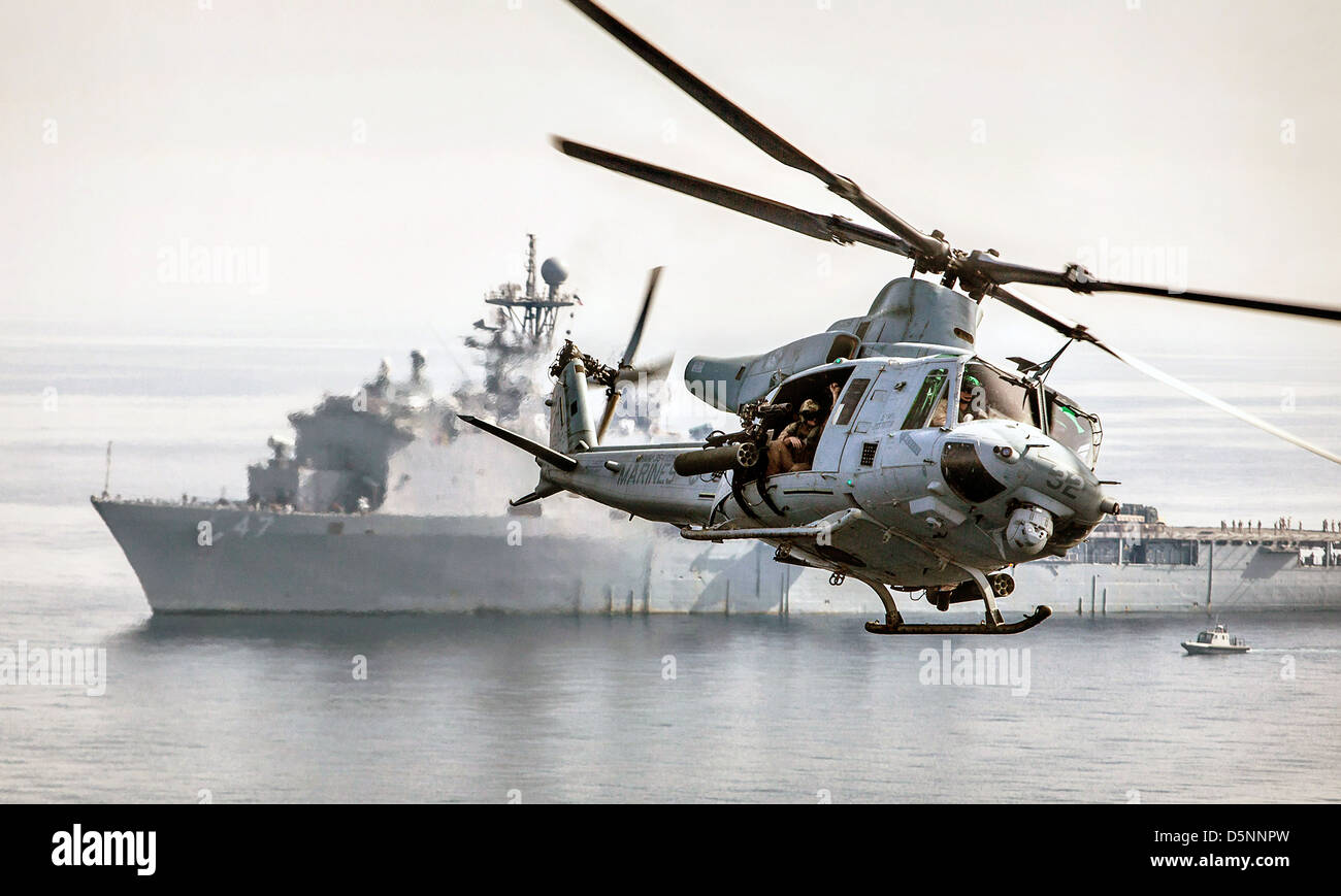 A US Marine Corps UH-1N Huey flies past the USS Rushmore March 29, 2013 ...