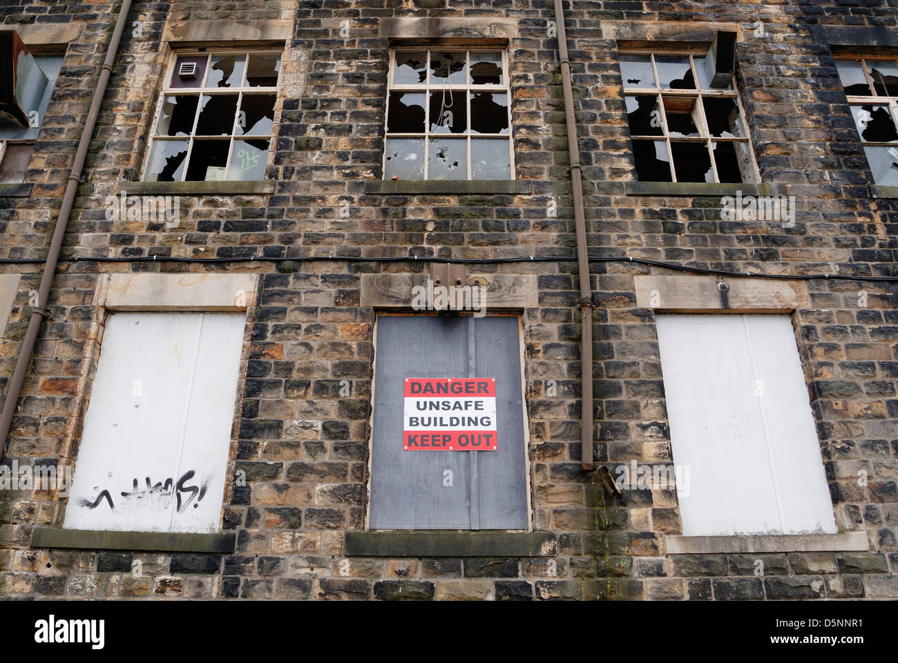 Danger unsafe building keep out sign on a disused mill building in ...