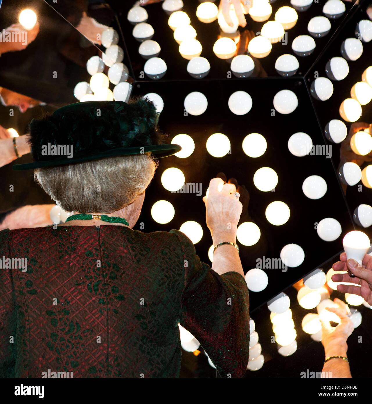 Queen Beatrix of The Netherlands opens the Philips museum by turning a lightbulb into a light ...