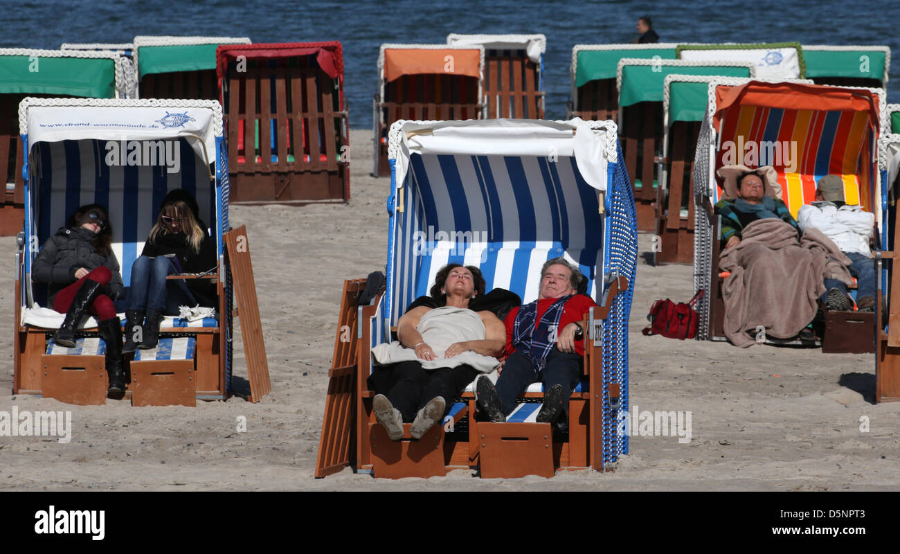 The first roofed wicker beach chairs are occupied by visitors at ...