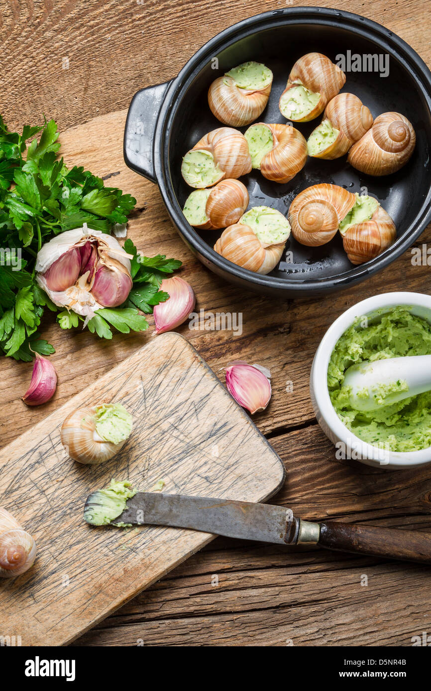 Preparing baked snails with garlic and parsley Stock Photo - Alamy