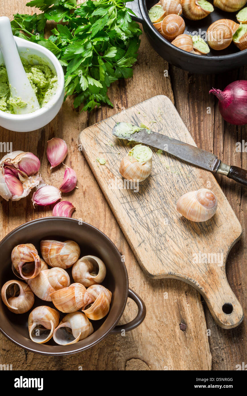 Closeup of preparing baked snails with garlic butter Stock Photo - Alamy