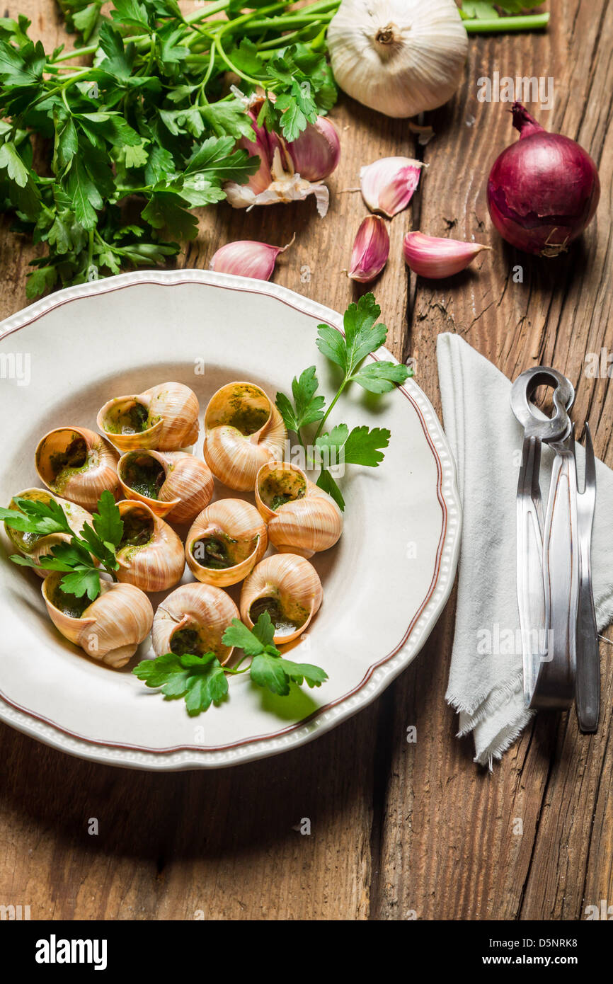 Baked snails with garlic butter and parsley Stock Photo - Alamy