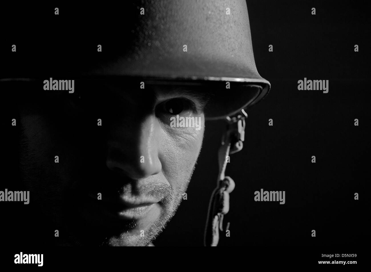 Portrait of a WW2 U.S. soldier in deep shadow against a black ...