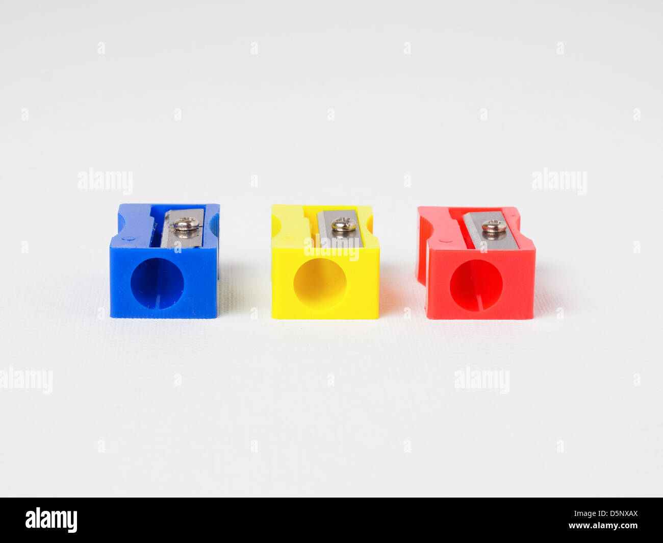 three different colors sharpener on white background Stock Photo - Alamy