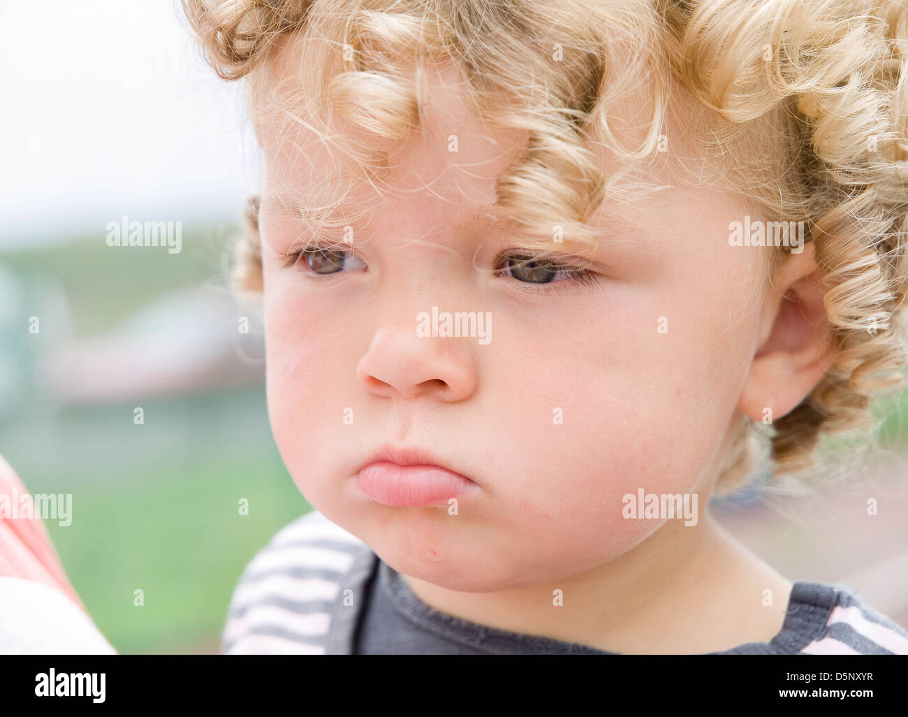 A blond hair girl with a seious expression on her face Stock Photo - Alamy