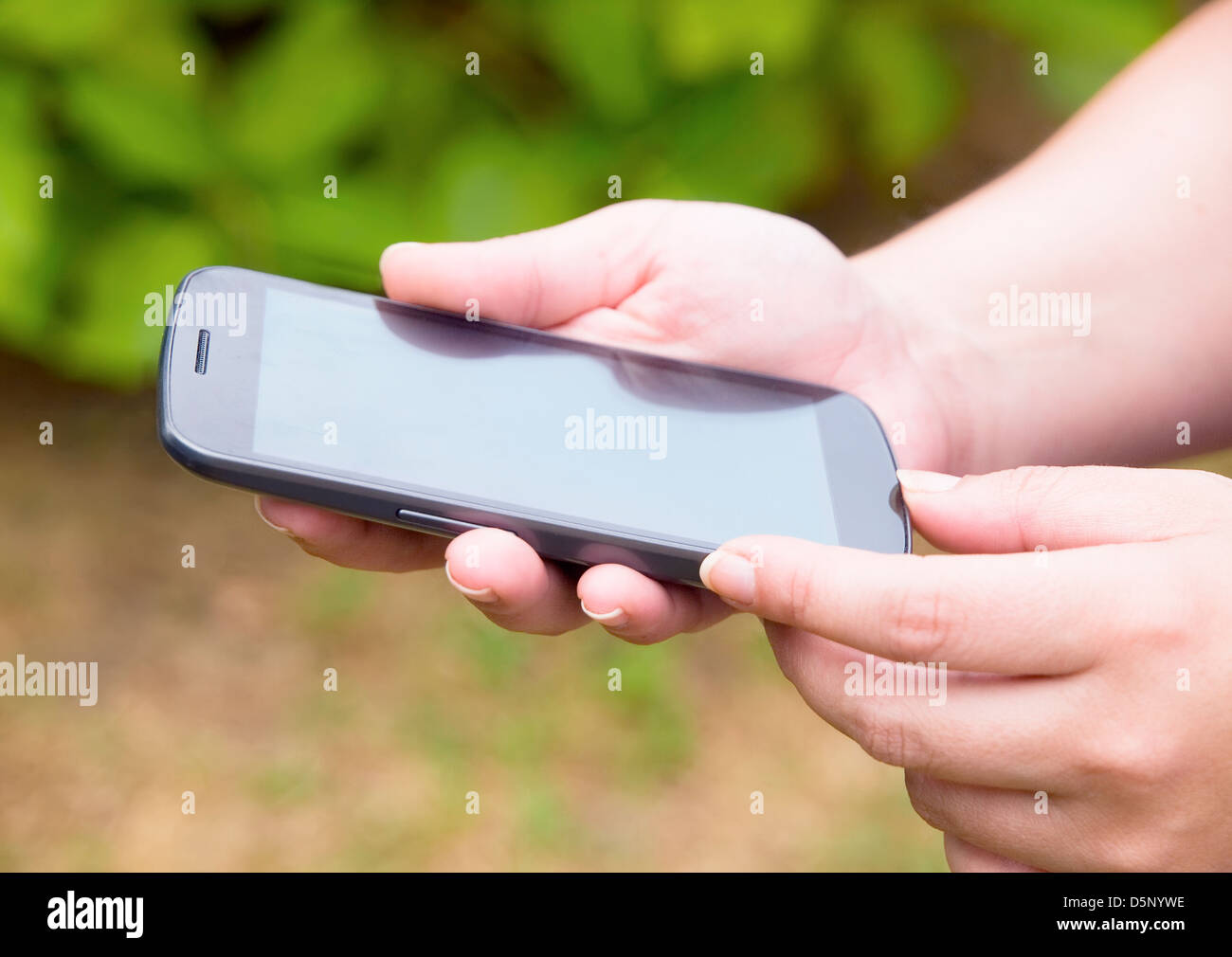 Woman hand touching screen on modern mobile smart phone on natural ...