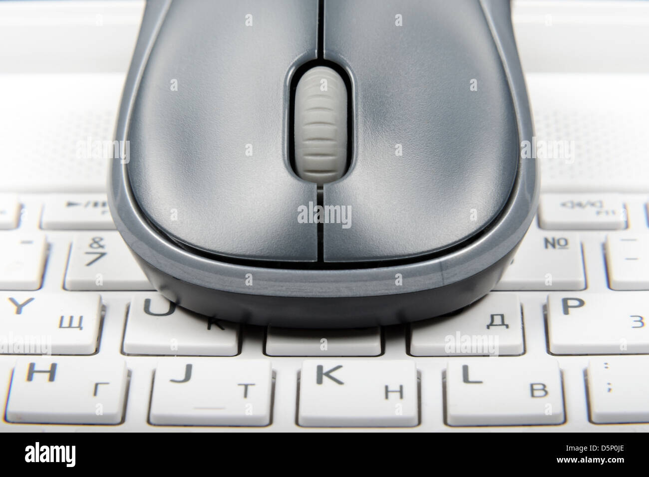 A wireless mouse placed on laptop keyboard Stock Photo - Alamy