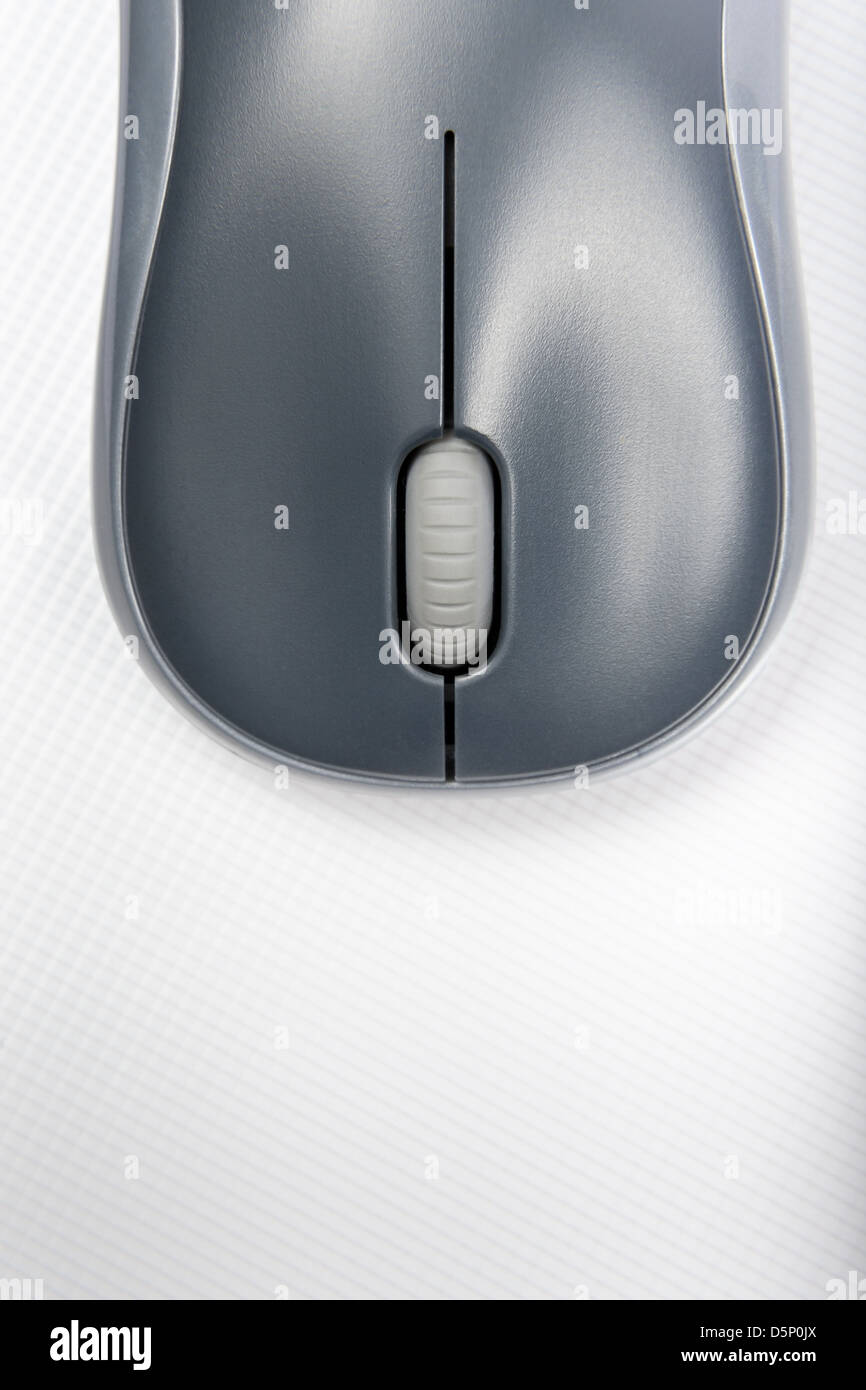 A wireless mouse positioned vertically on the cover of a laptop Stock ...