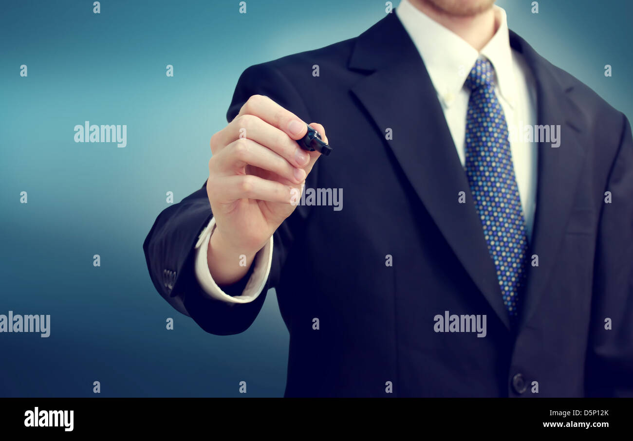 Business man holding a pen on blue background Stock Photo - Alamy