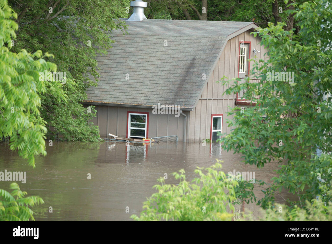 This image highlights a canoe navigating floodwaters in the Midwest ...
