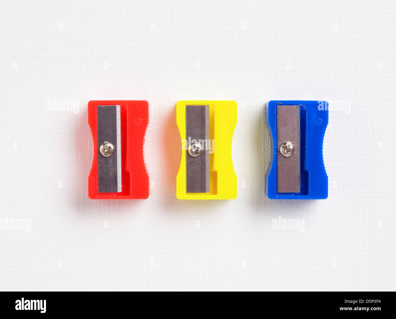 three different colors sharpener on white background Stock Photo - Alamy