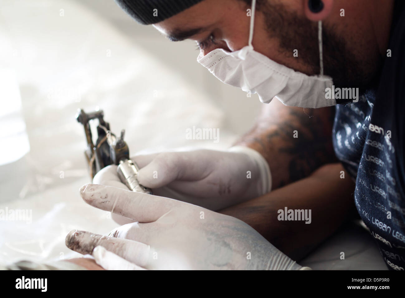 Tattoo artist doing his job Stock Photo - Alamy