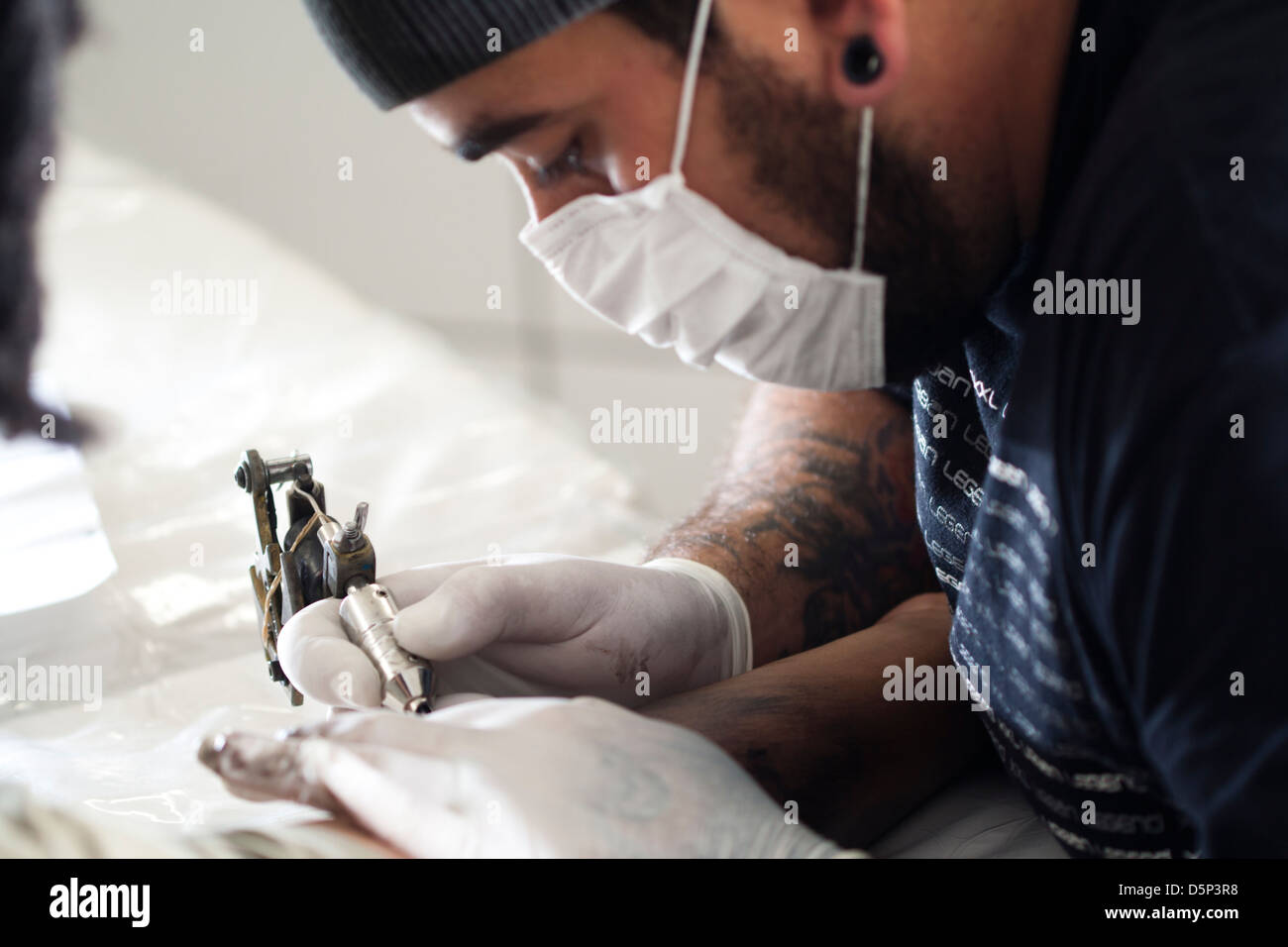 Tattoo artist doing his job Stock Photo - Alamy