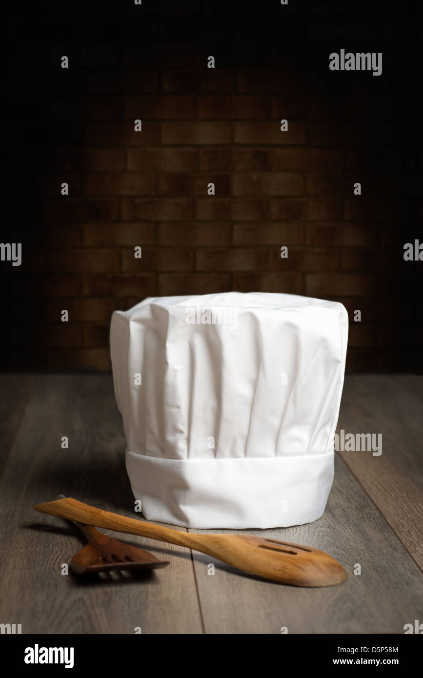 Chef's hat with wooden spoons on abstract wall background Stock Photo ...