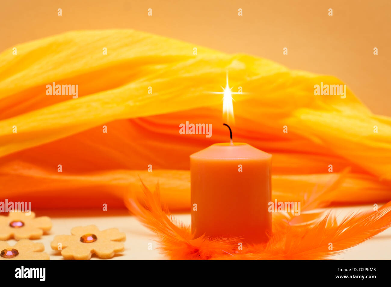 yellow background with a burning candle Stock Photo - Alamy