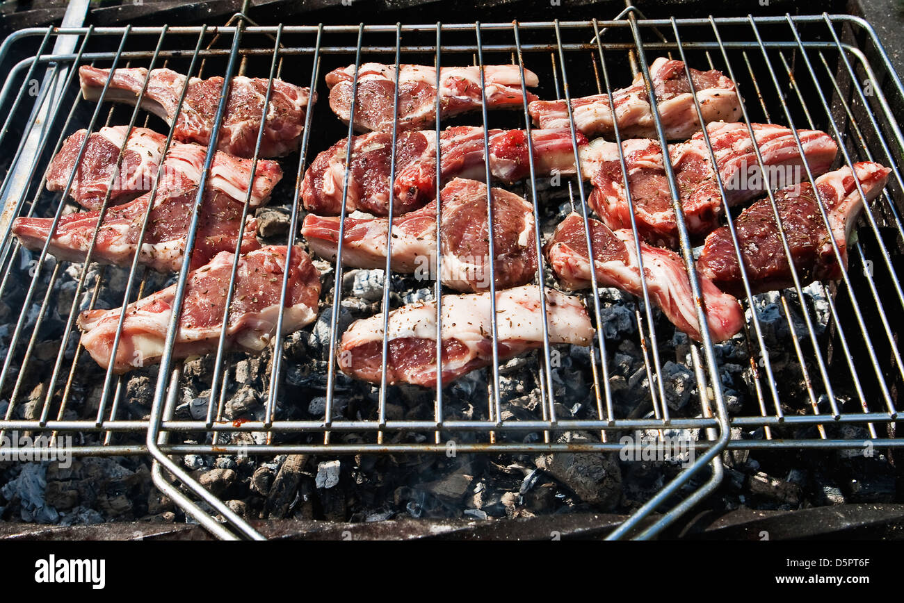 Raw mutton chops on a grill Stock Photo - Alamy